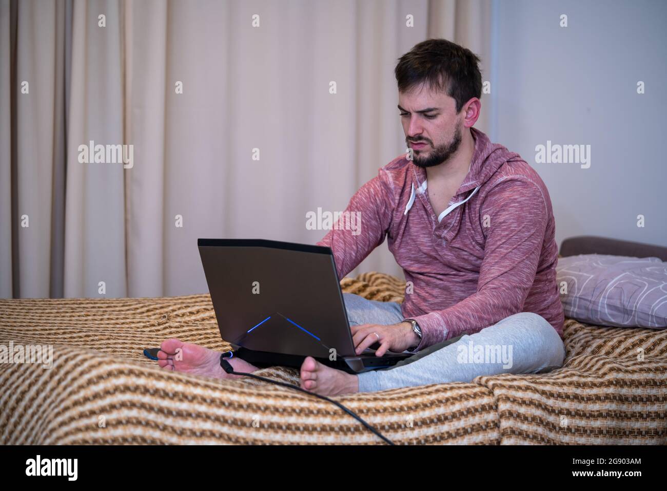 Anxious young Caucasian man working remotely on the computer sitting on ...