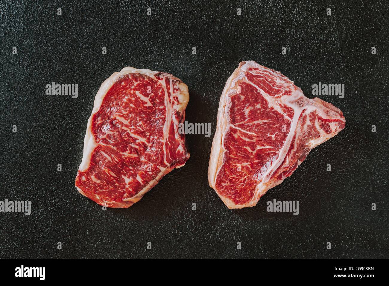 Two beef steaks on the black background Stock Photo - Alamy