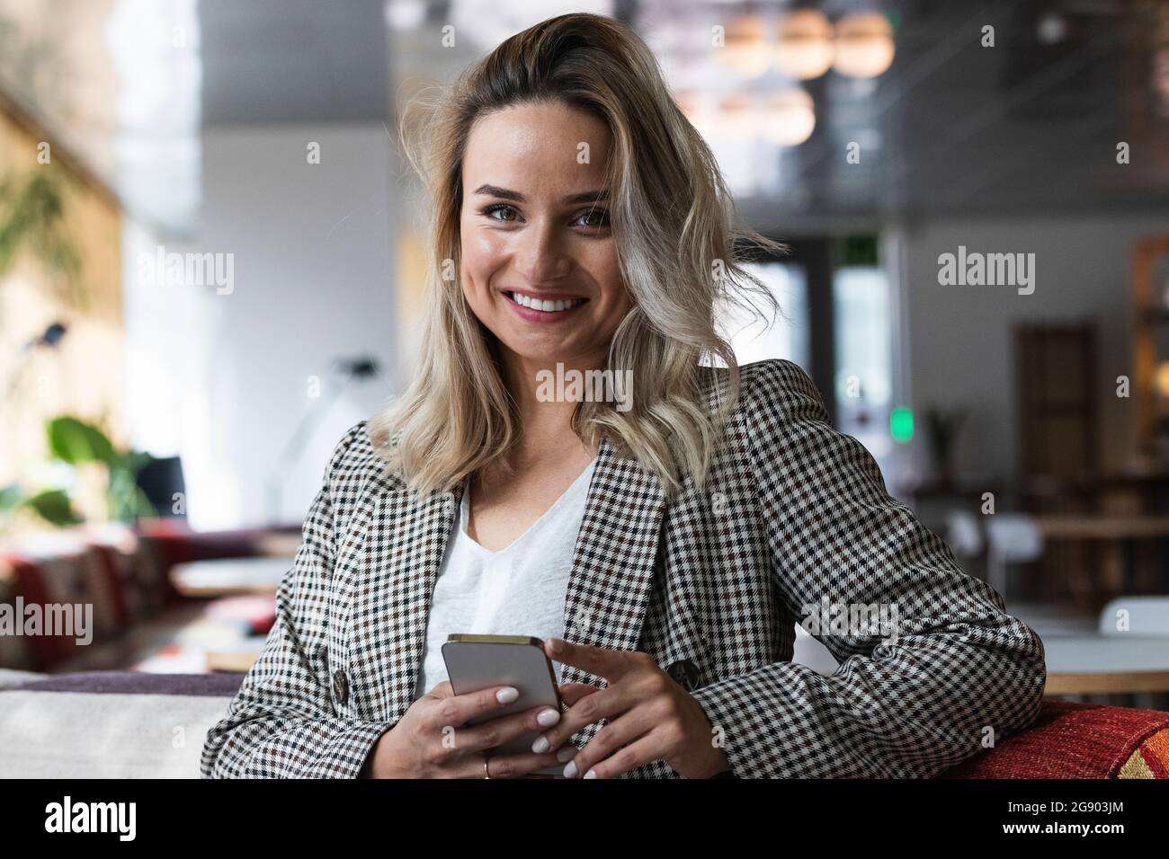 Beautiful female professional holding mobile phone at cafe Stock Photo ...
