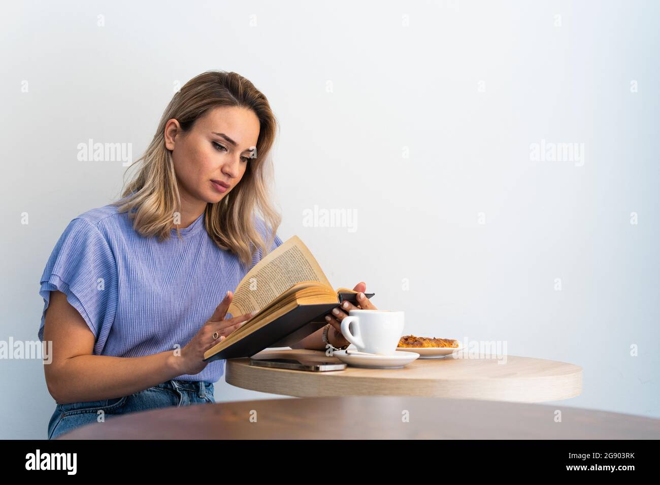 Woman reading book table hi-res stock photography and images - Alamy