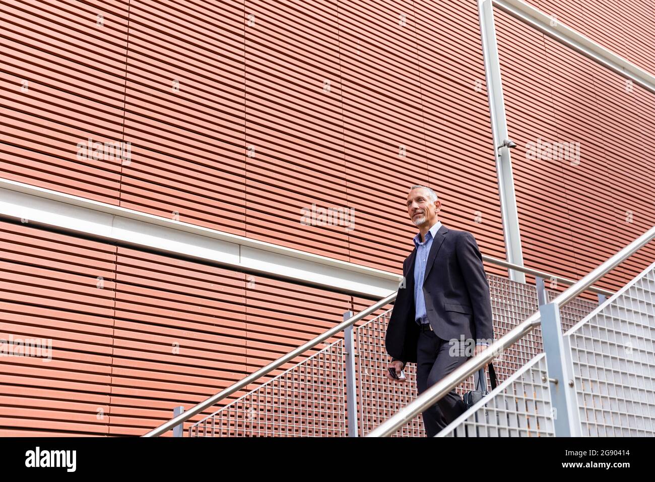 Male professional moving down from staircase Stock Photo - Alamy