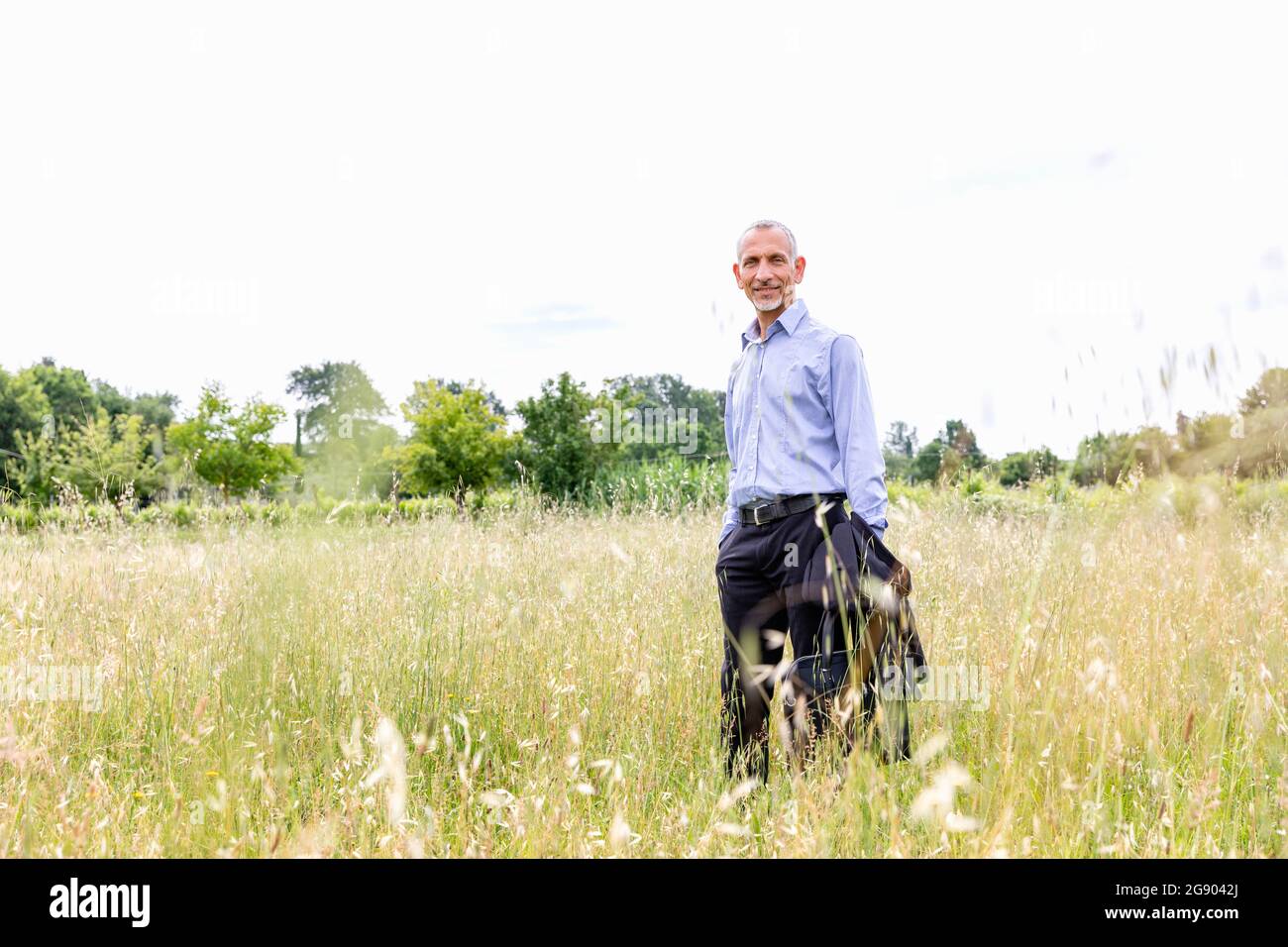 Male professional standing in field Stock Photo - Alamy