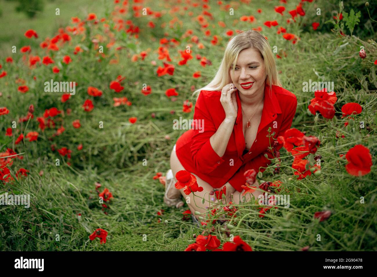 beautiful girl in a field with red poppies in a red shirt Stock Photo ...