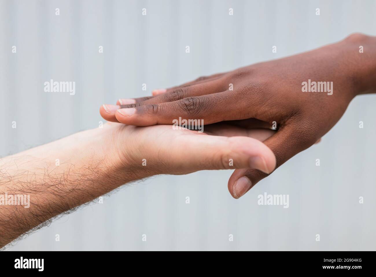 Woman and man touching hands by wall Stock Photo - Alamy