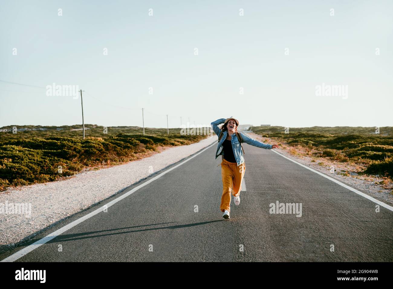 Mid adult woman running of road hi-res stock photography and images - Alamy