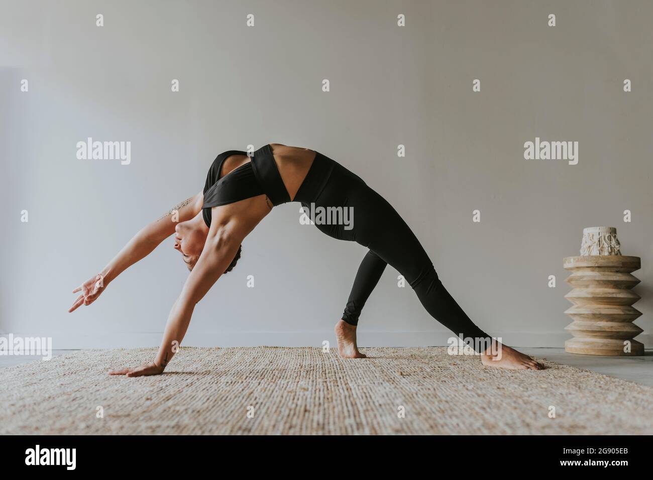 Female yoga instructor bending backwards while practicing at studio ...