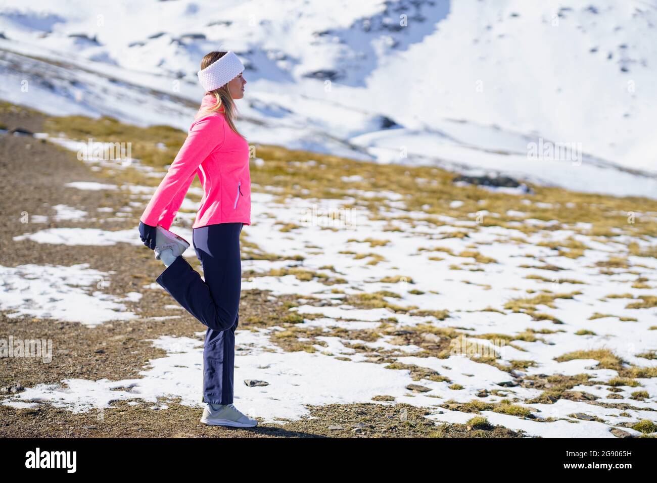 Female sportsperson doing stretching exercise during winter Stock Photo ...