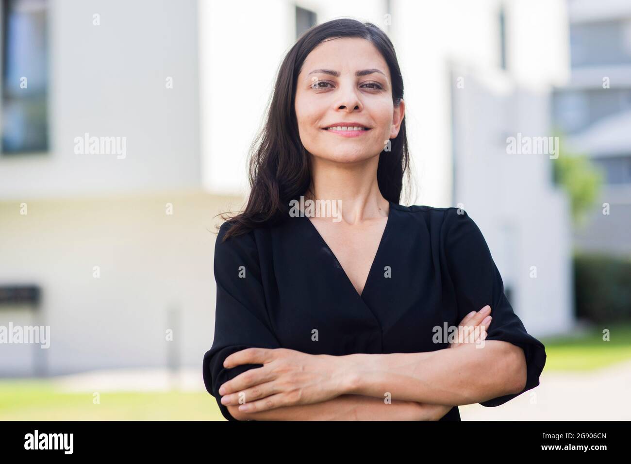 Positive female standing crossed arms hi-res stock photography and ...