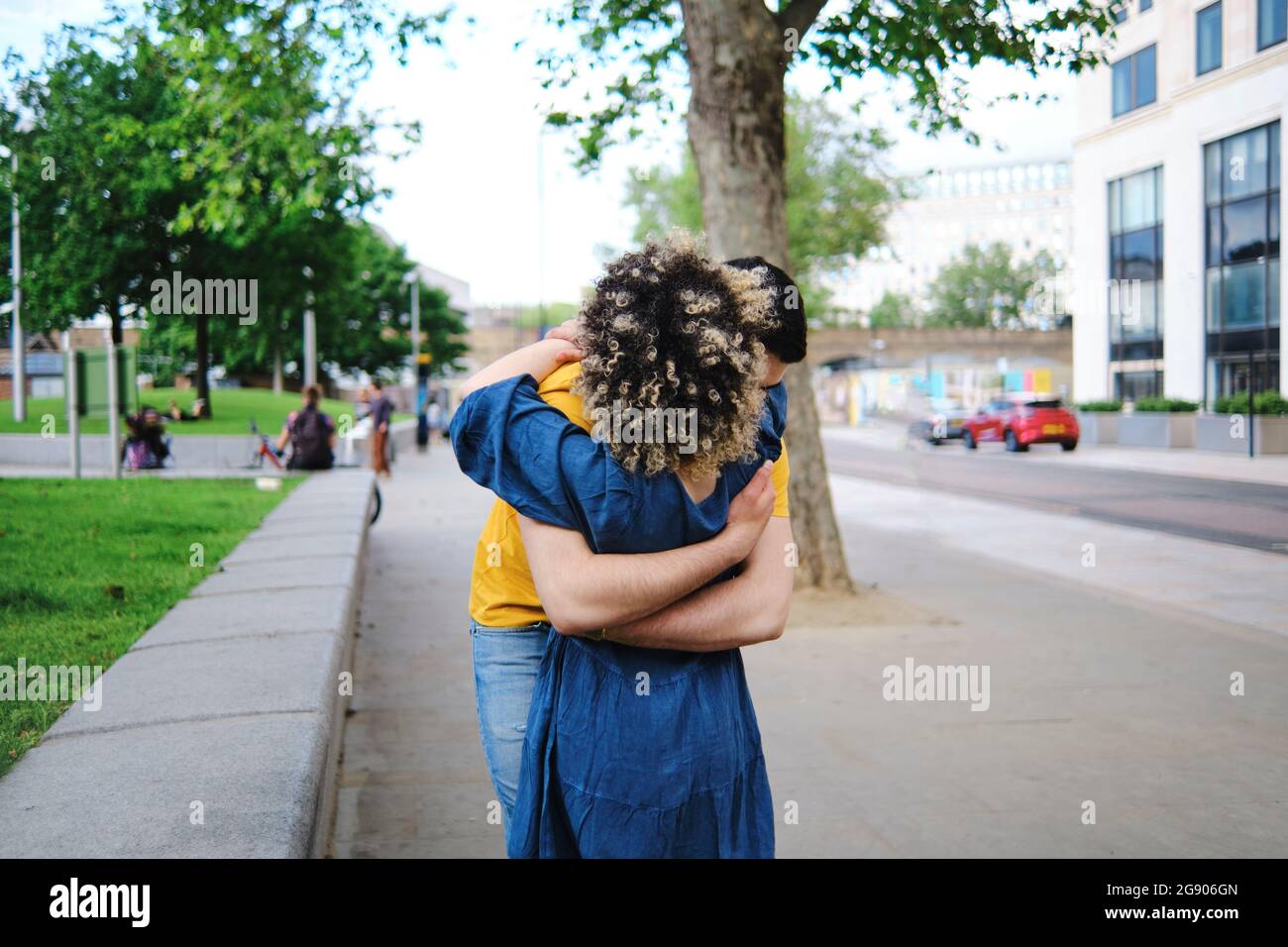 Young couple hugging each other standing at park Stock Photo - Alamy