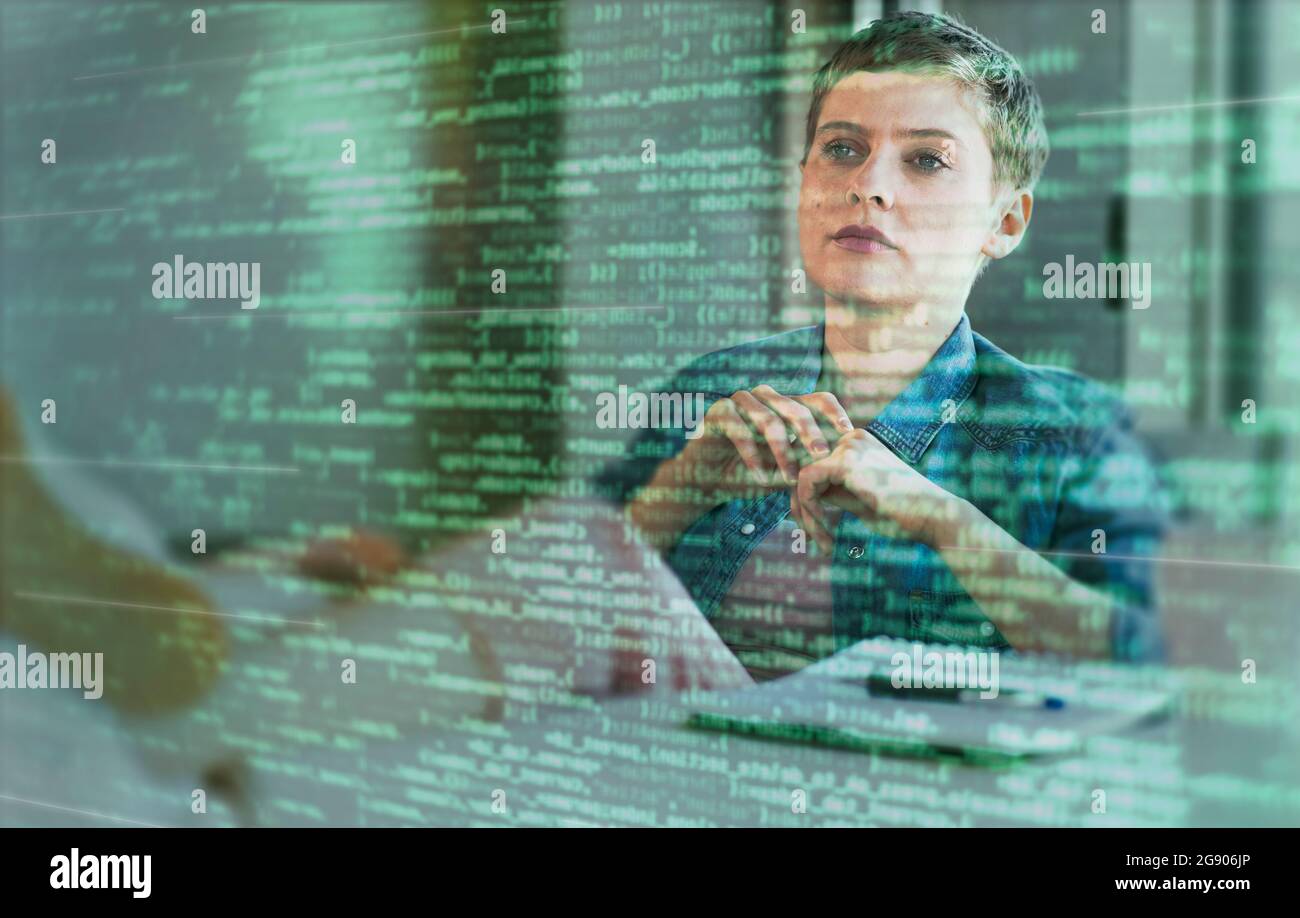 Female professional looking at binary codes on glass at office Stock ...