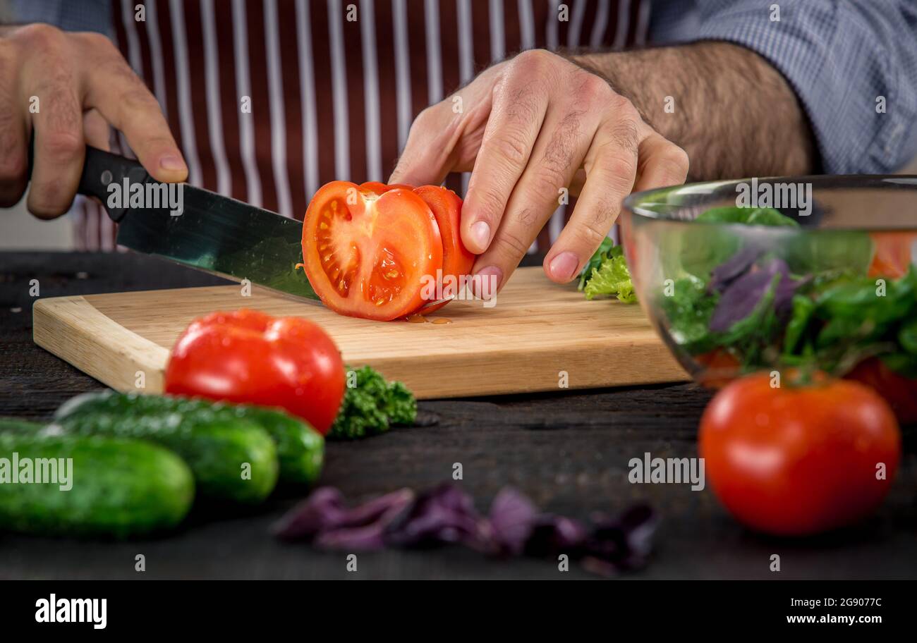 Male hands cutting vegetables for salad Stock Photo - Alamy