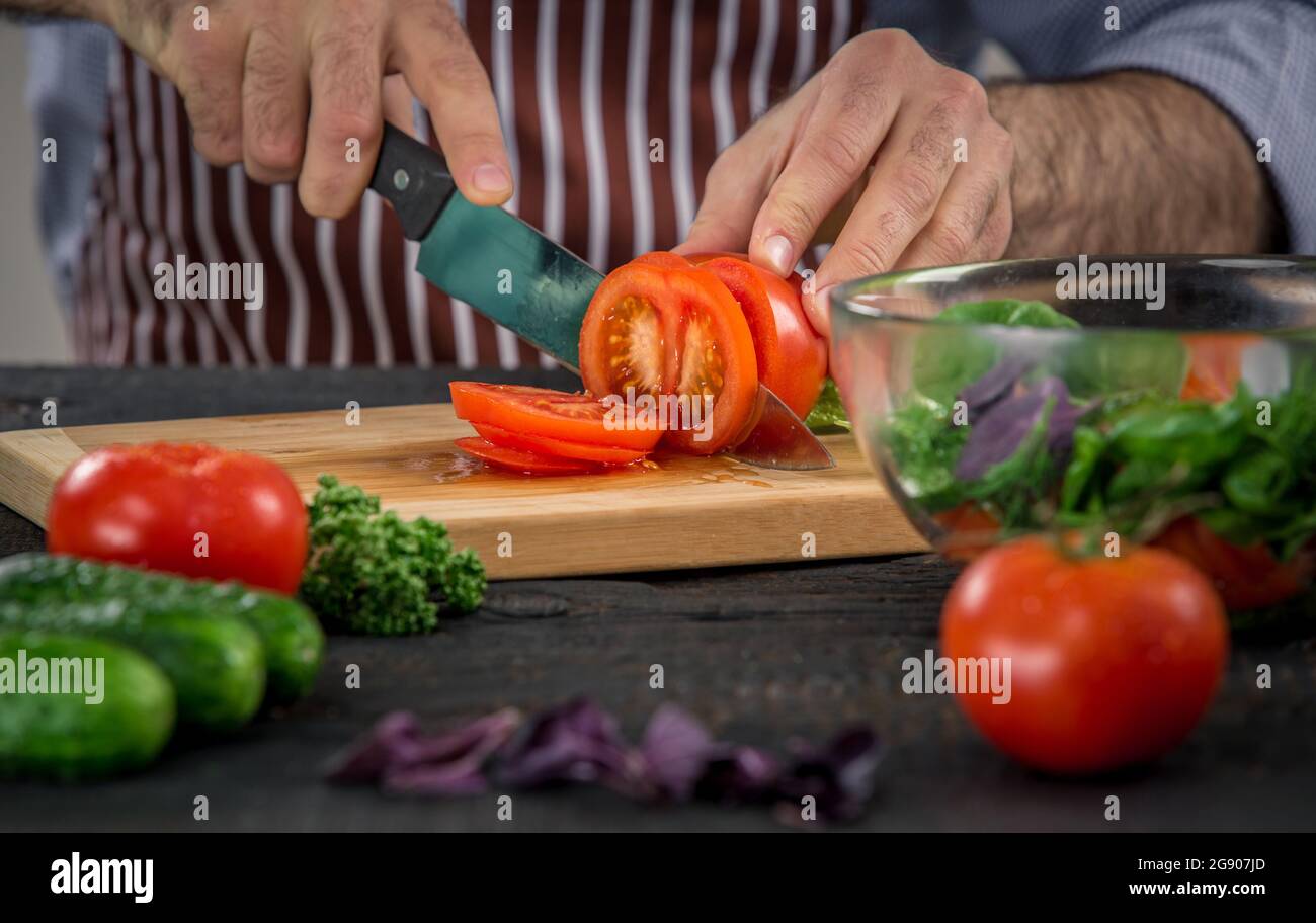 Male hands cutting vegetables for salad Stock Photo - Alamy