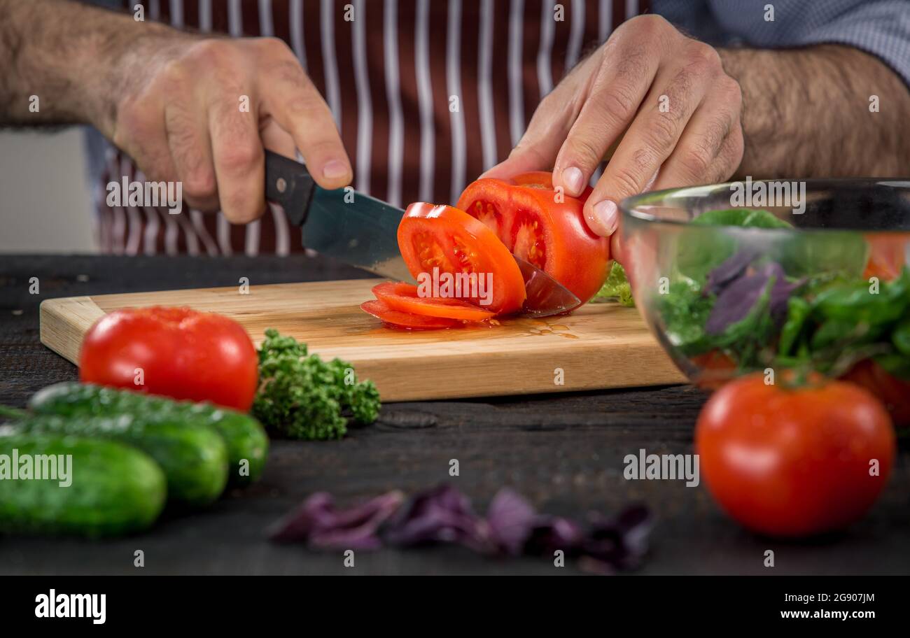 Male hands cutting vegetables for salad Stock Photo - Alamy