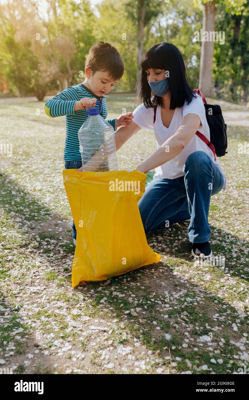 Mother and son cleaning plastic garbage at park Stock Photo - Alamy