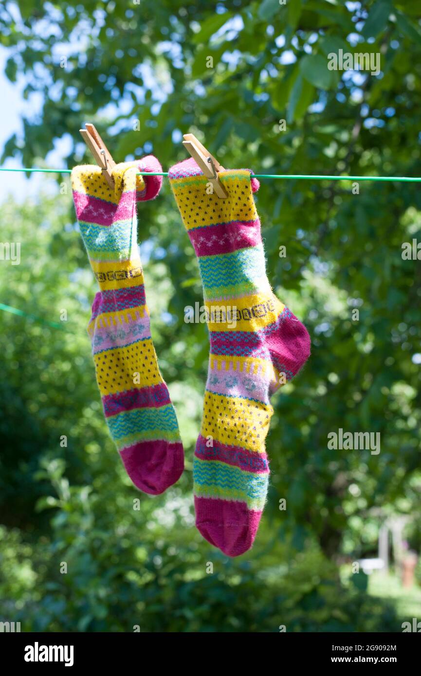 Pair of colorful socks drying on clothesline Stock Photo - Alamy