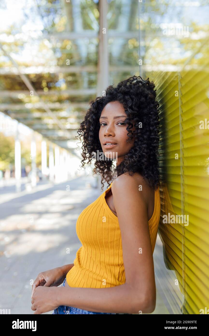 Beautiful young woman leaning on window Stock Photo - Alamy