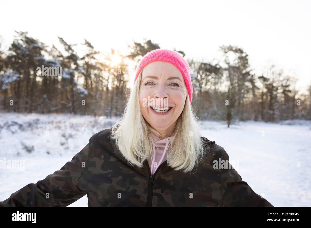 Happy blond woman wearing pink knit hat Stock Photo - Alamy