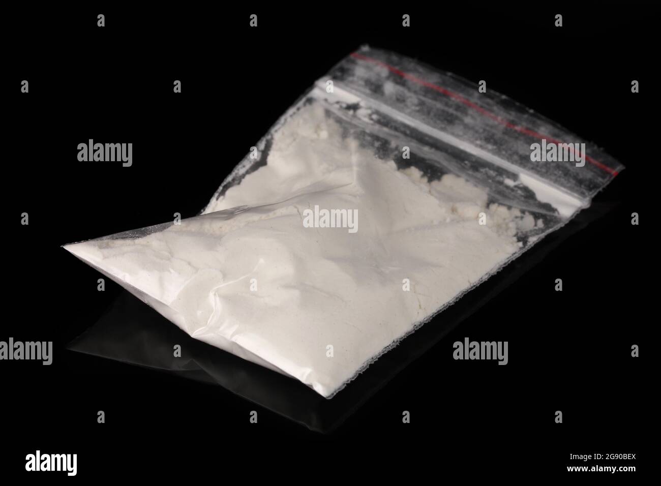 Cocaine in package on black background Stock Photo - Alamy