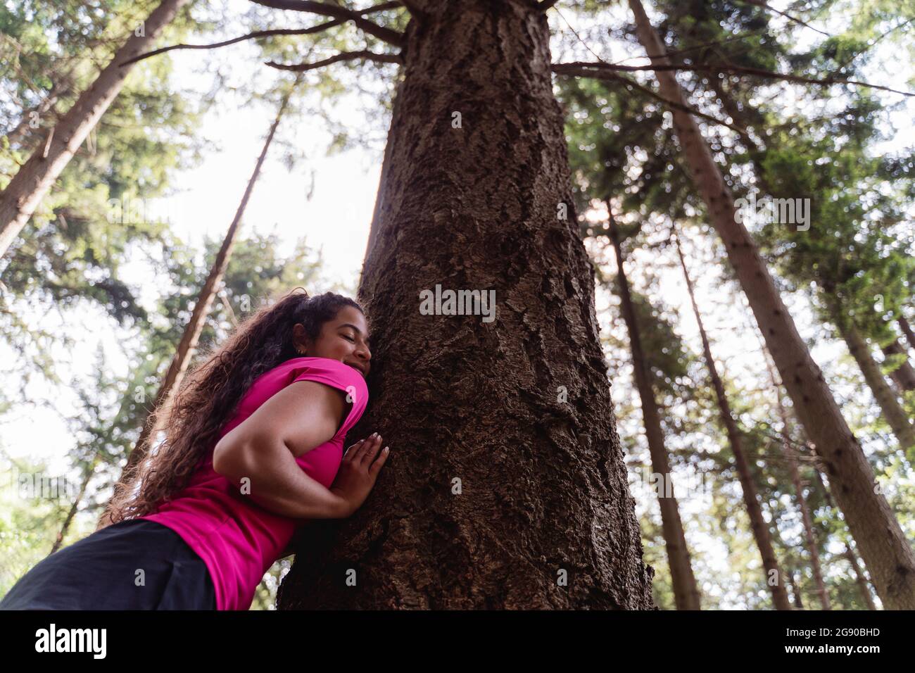 Young woman hugging tree in woodland hi-res stock photography and ...