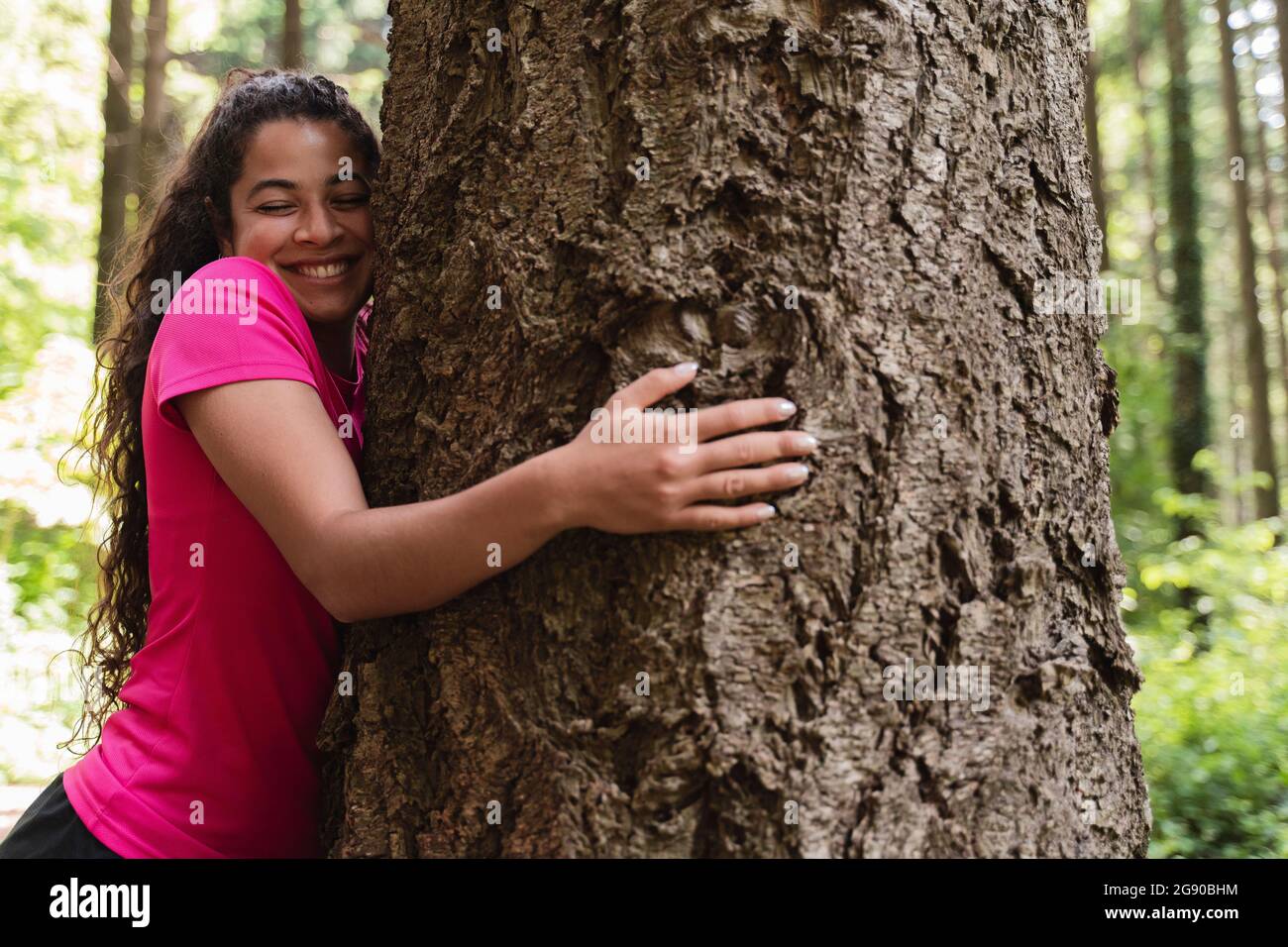 Young woman hugging tree in woodland hi-res stock photography and ...
