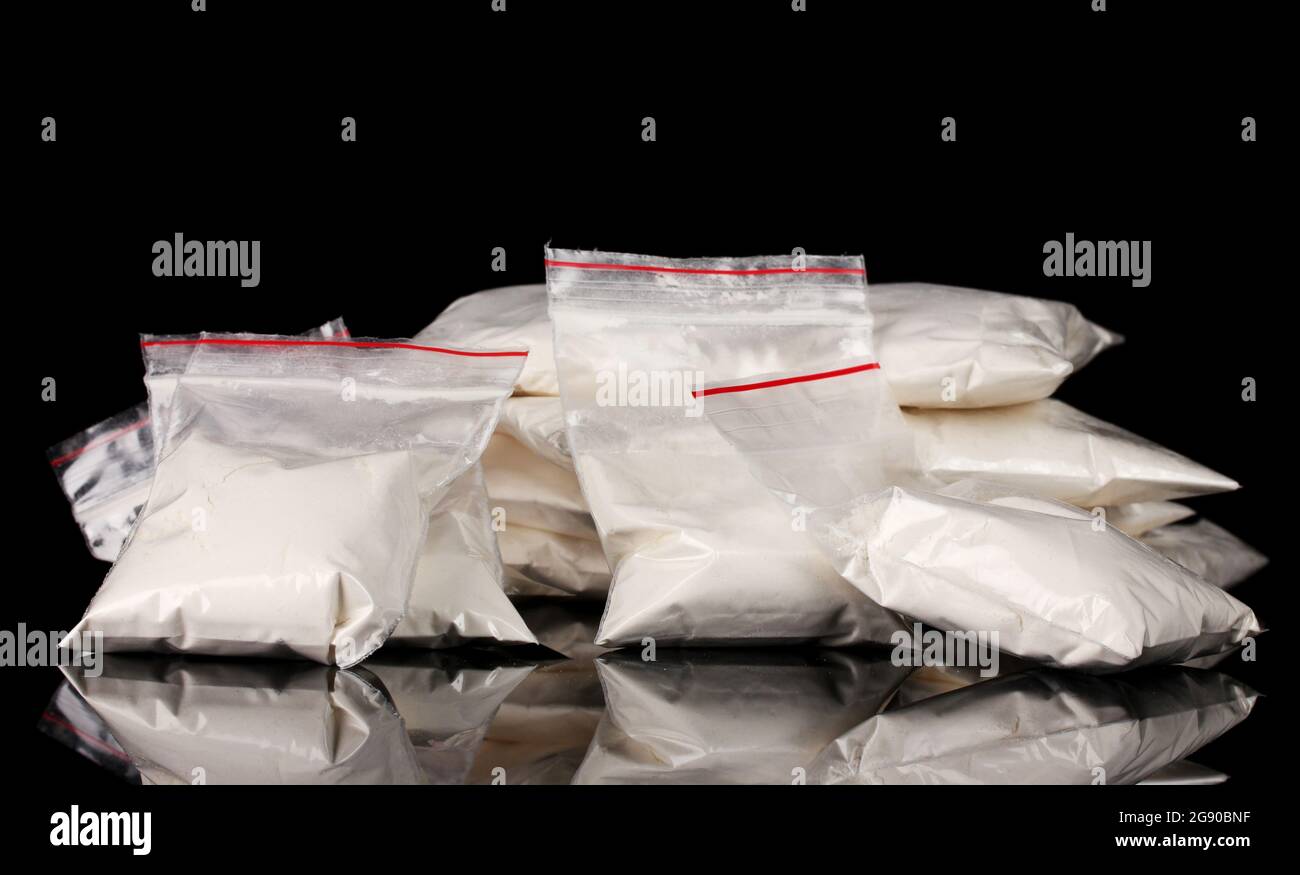 Cocaine in packages on black background Stock Photo - Alamy