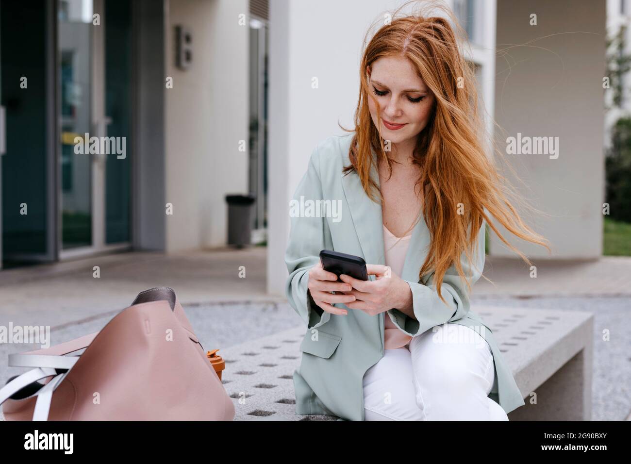 Female professional using smart phone on bench Stock Photo - Alamy