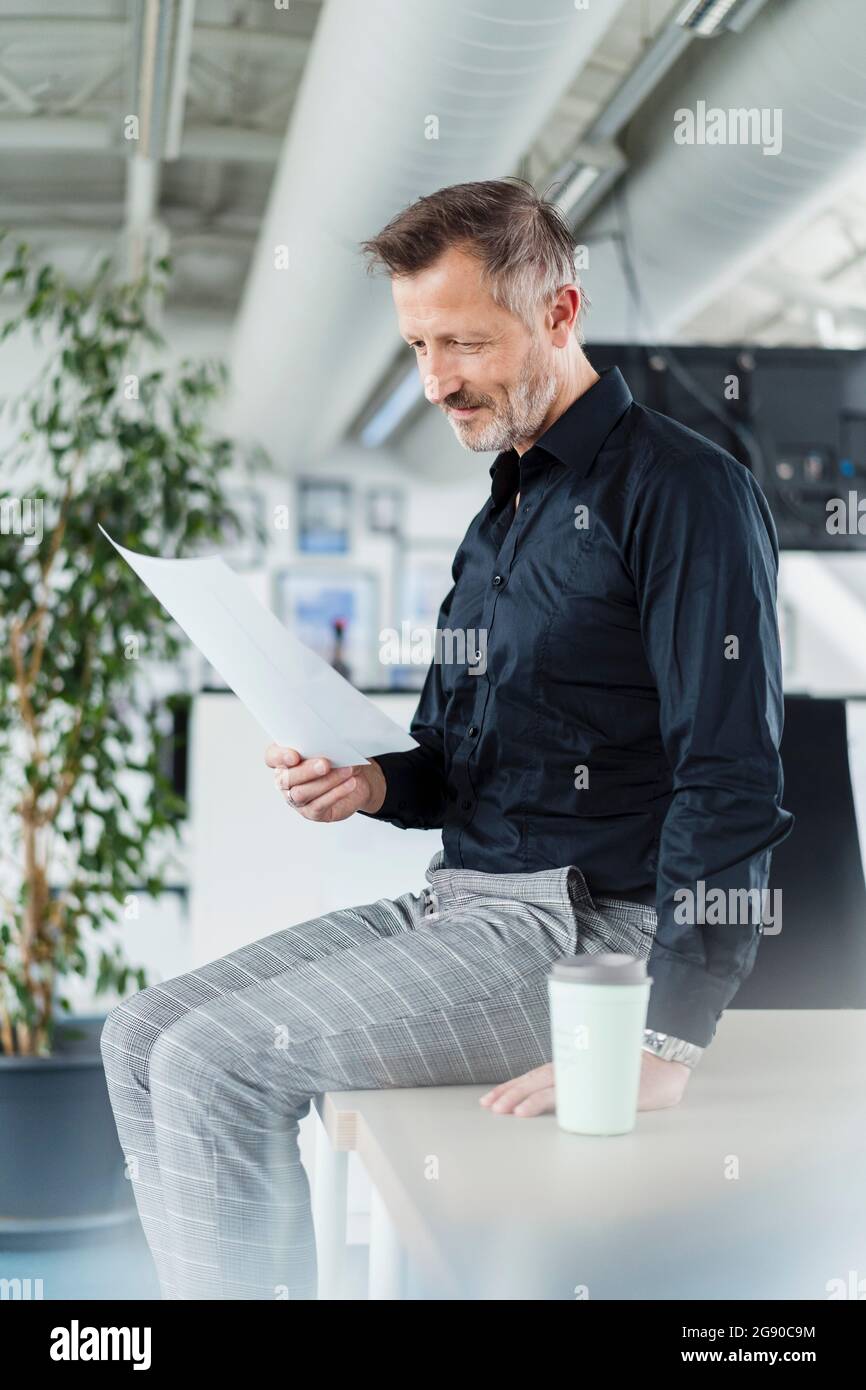 Professional man sitting desk reading hi-res stock photography and ...