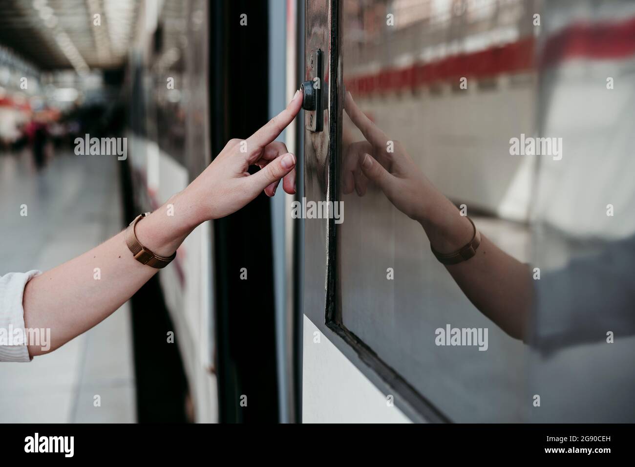 Young woman pressing button on train at railroad station Stock Photo ...