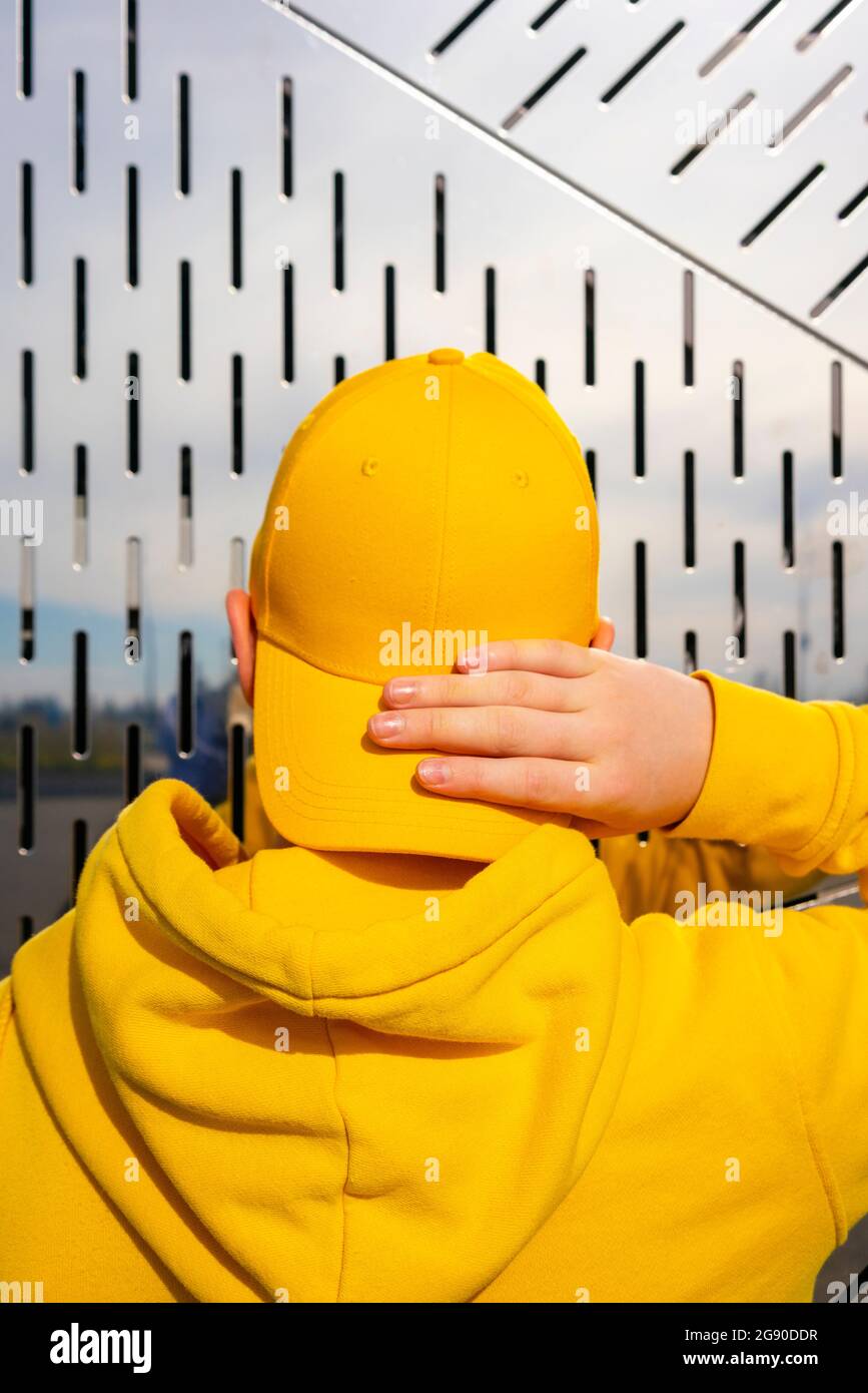 Pre-adolescent male skater adjusting yellow cap on sunny day Stock ...