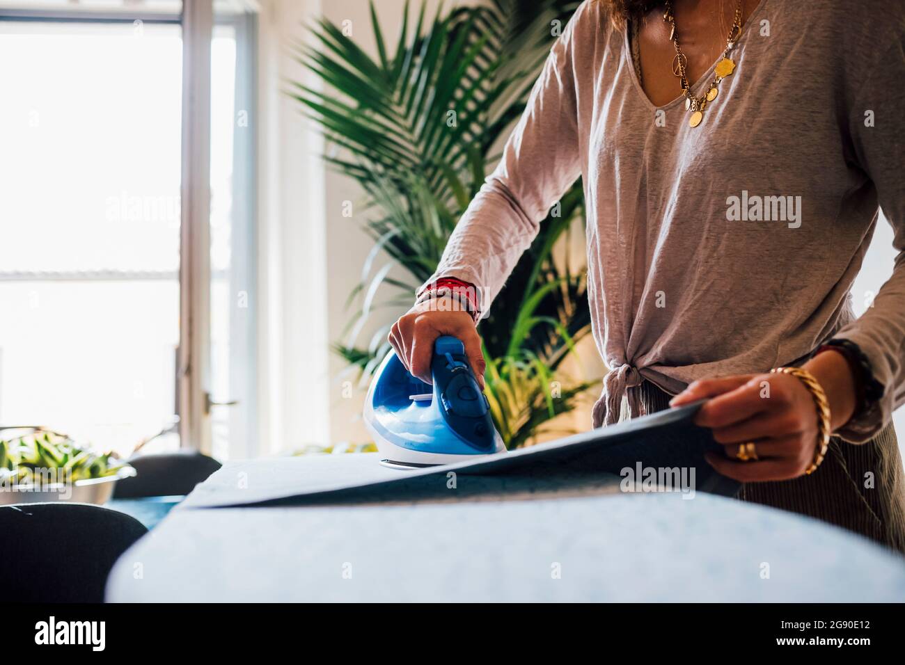 Woman ironing clothes while standing at home Stock Photo - Alamy