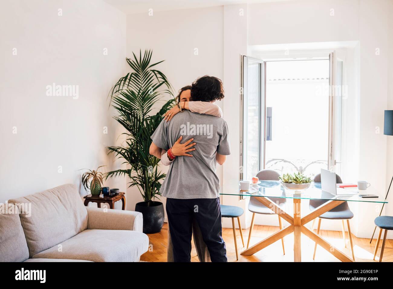 Couple hugging each other while standing at home Stock Photo - Alamy