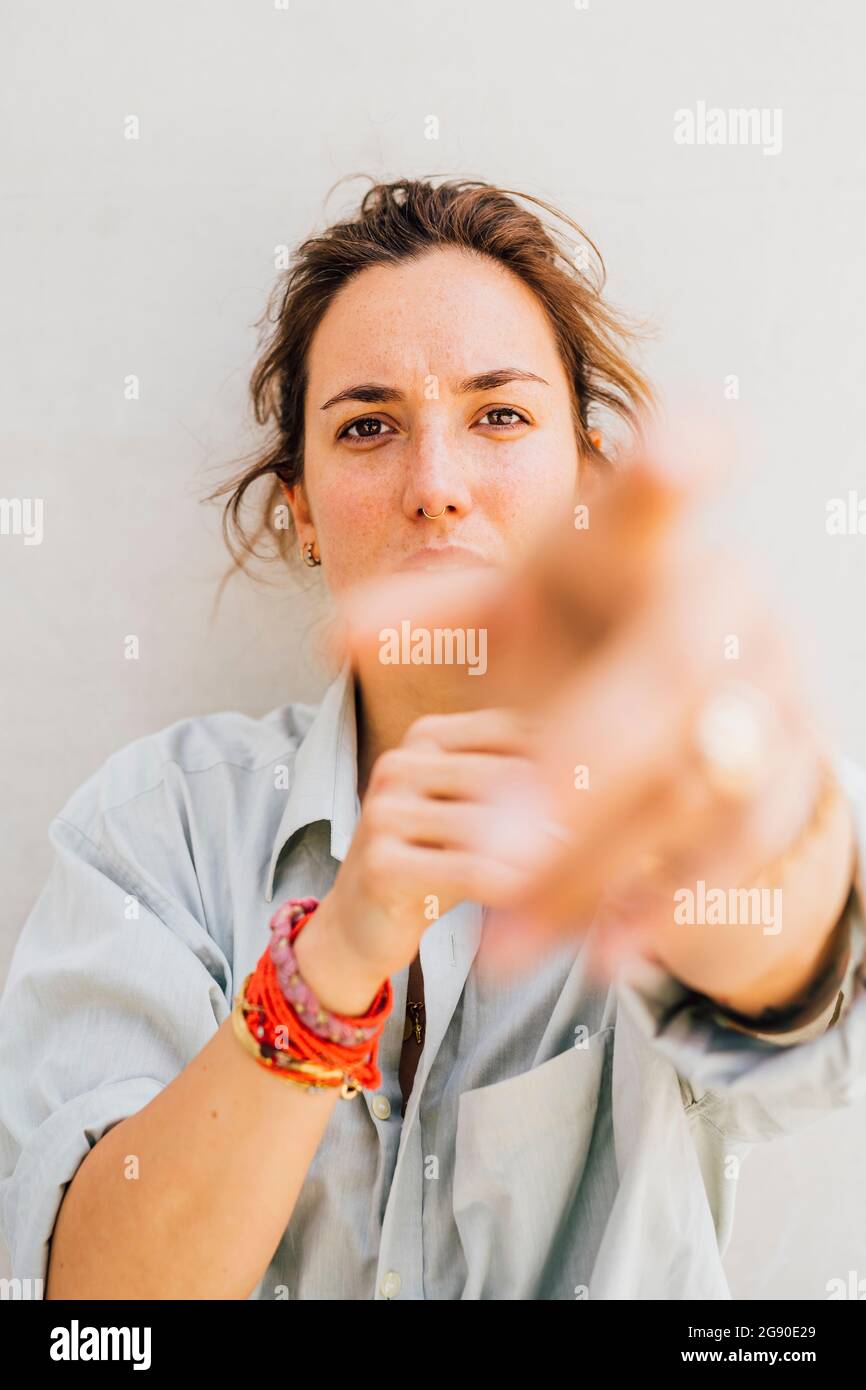 Woman pointing while standing in front of wall Stock Photo - Alamy