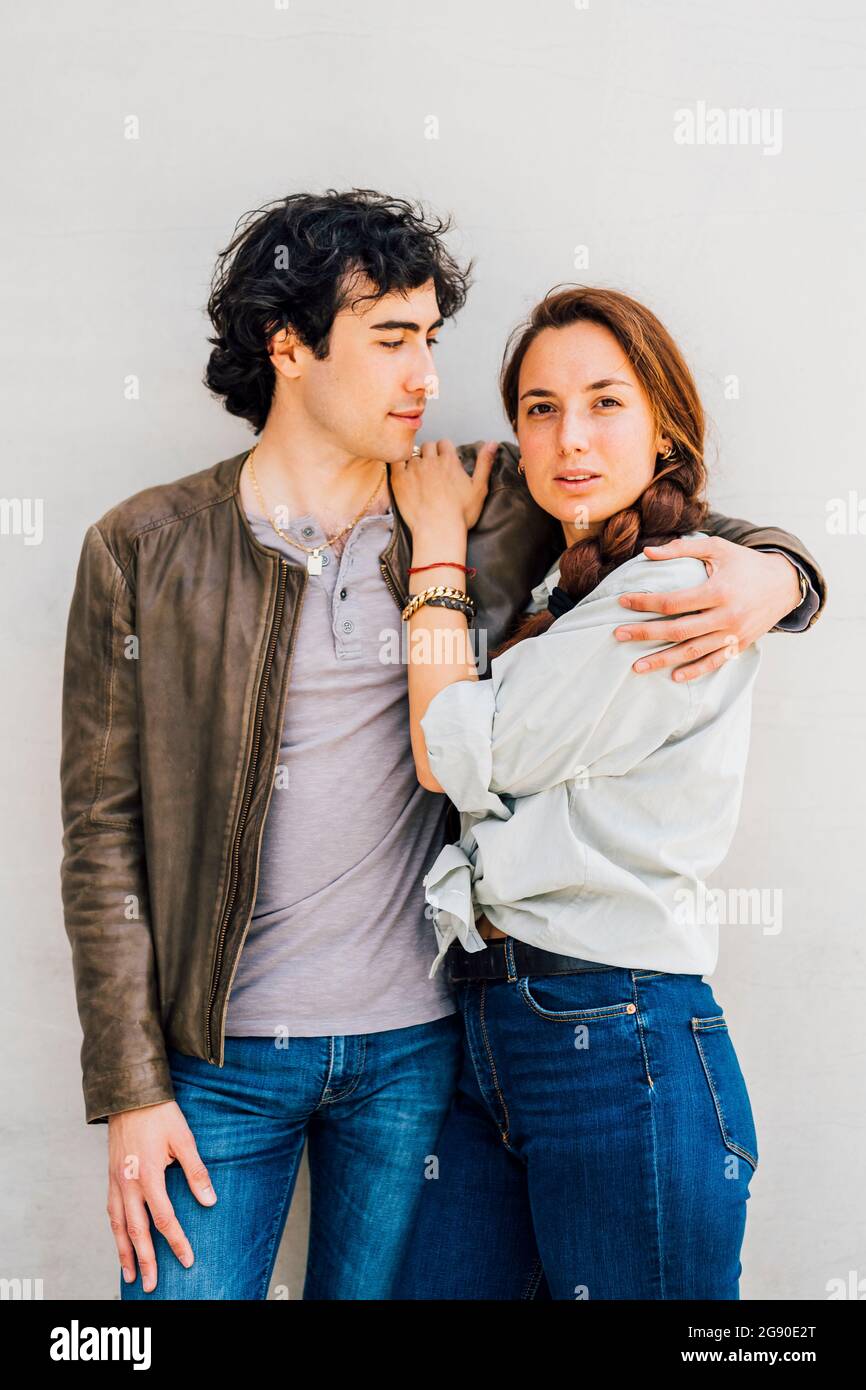 Boyfriend looking at girlfriend while standing in front of wall Stock ...