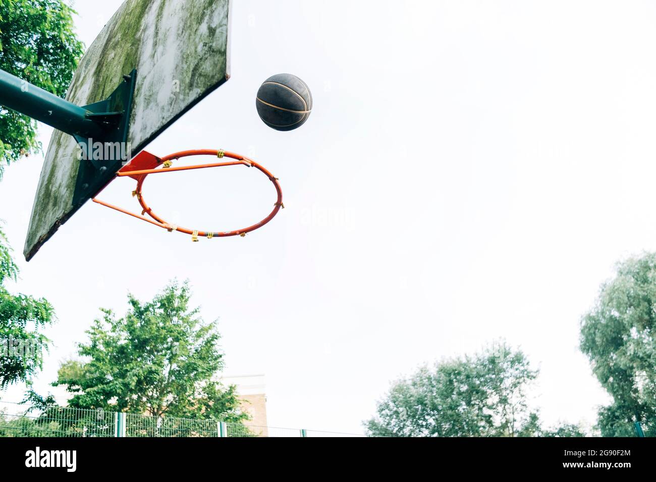 Basketball over hoop at court Stock Photo - Alamy
