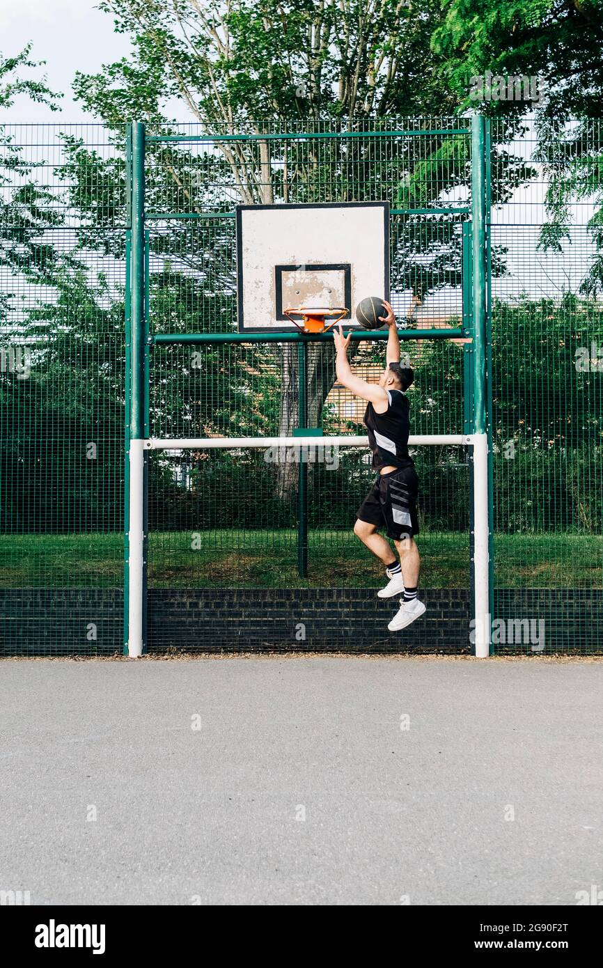 Athlete dunking basketball in hoop at court Stock Photo - Alamy