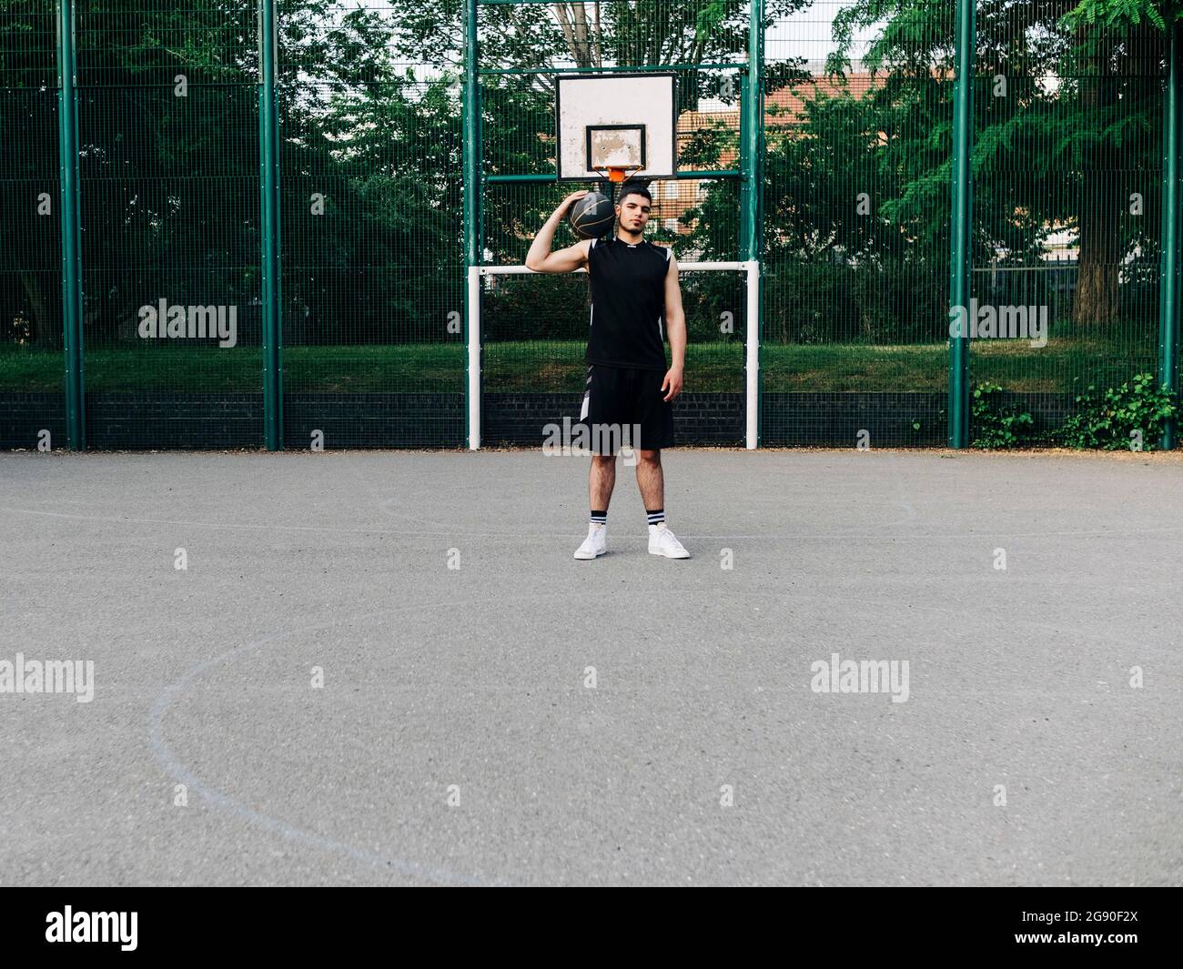 Basketball player standing on sports court Stock Photo - Alamy