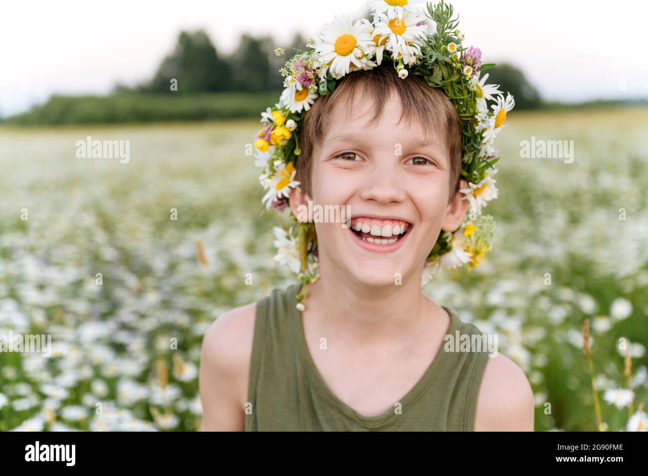 Boy wearing flower tiara smiling in field Stock Photo - Alamy