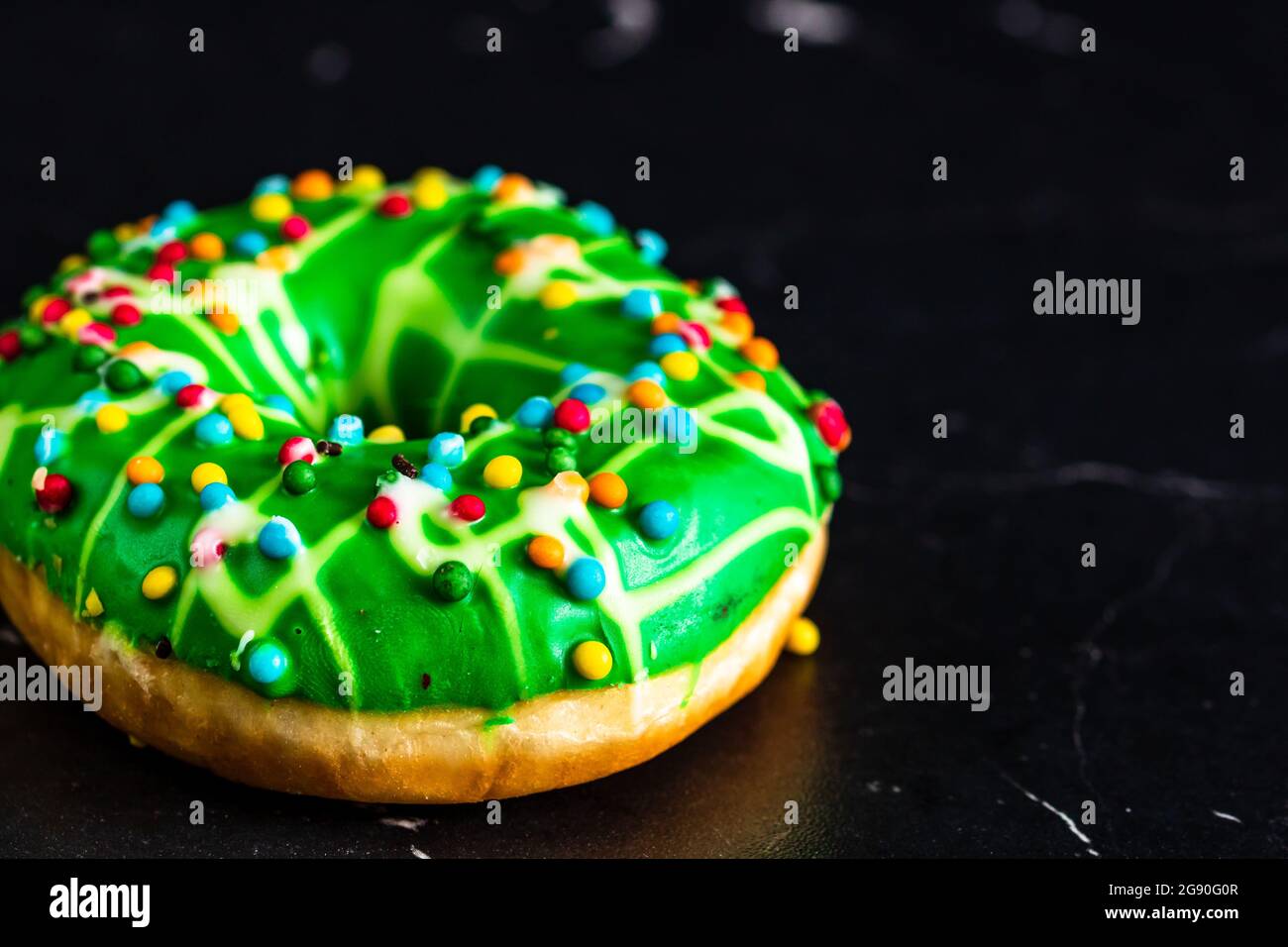 Green glazed donut with sprinkles isolated. Close up of colorful donut Stock Photo - Alamy