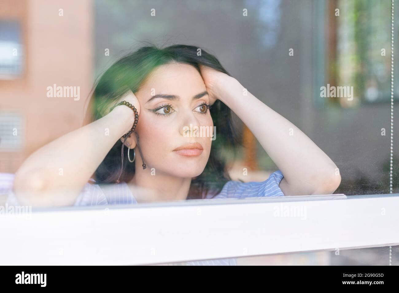 Female creative professional with head in hands looking away while ...