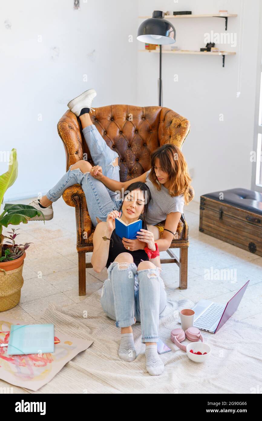 Female creative professionals reading notepad in art studio Stock Photo ...