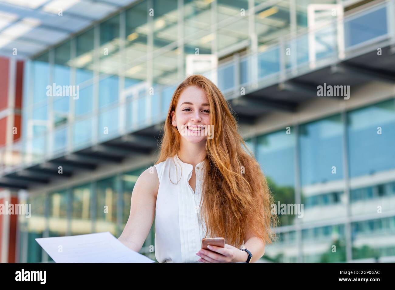 Beautiful female freelancer with document in front of building Stock ...
