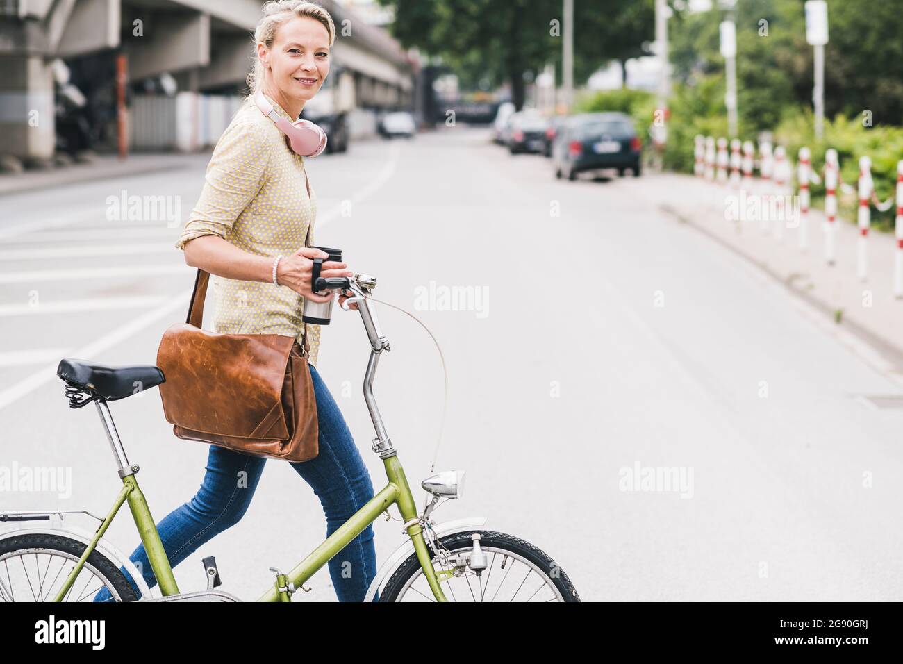 Female commuter wheeling bicycle on street Stock Photo - Alamy