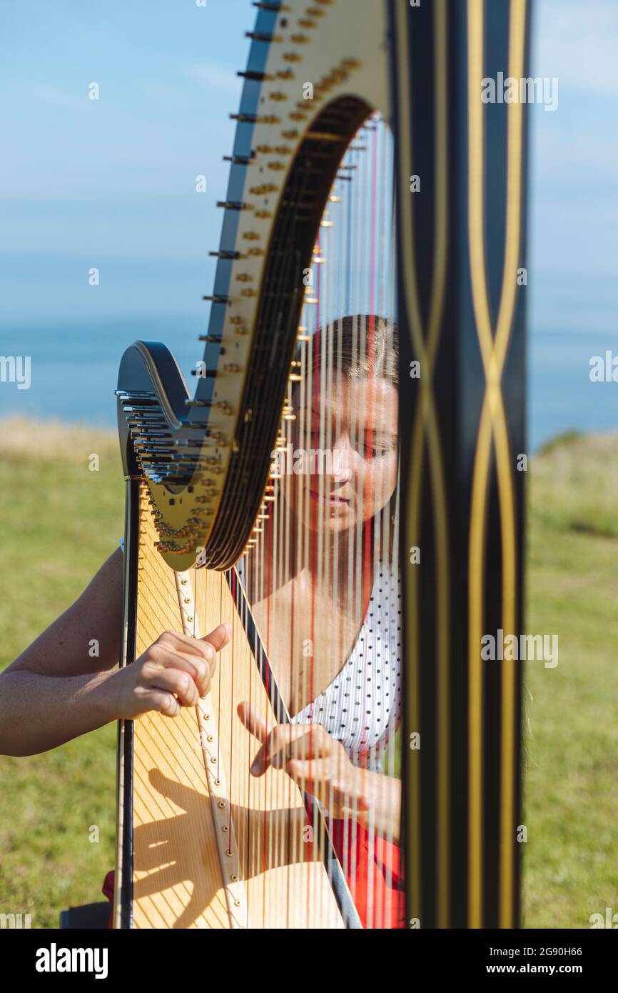 Person playing harp hi-res stock photography and images - Alamy