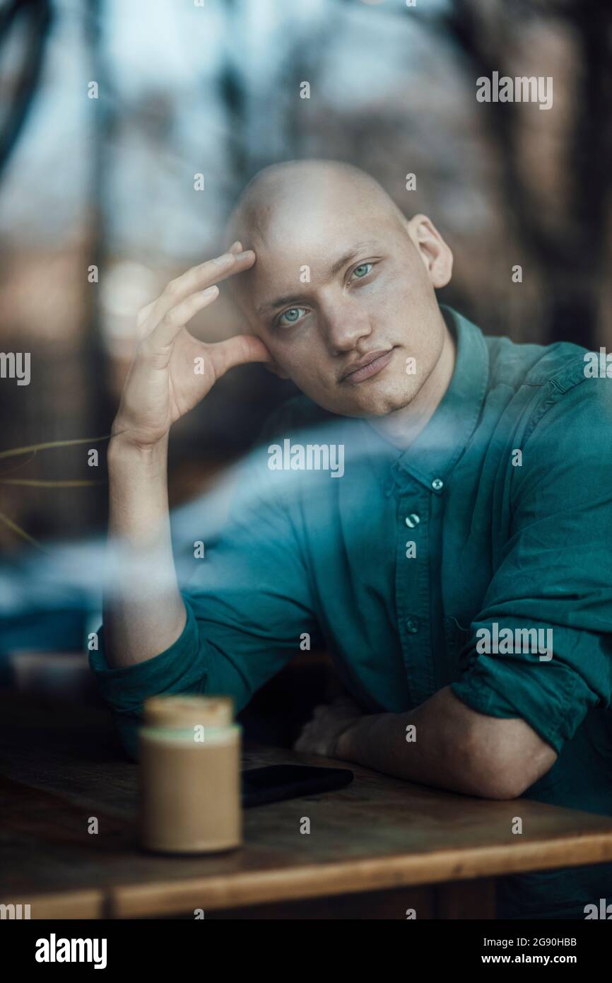 Male cafe owner staring through window Stock Photo - Alamy