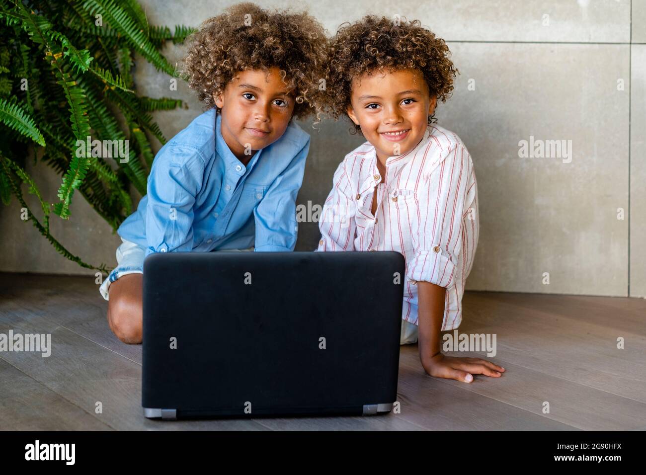 Two cute brothers sitting laptop hi-res stock photography and images ...