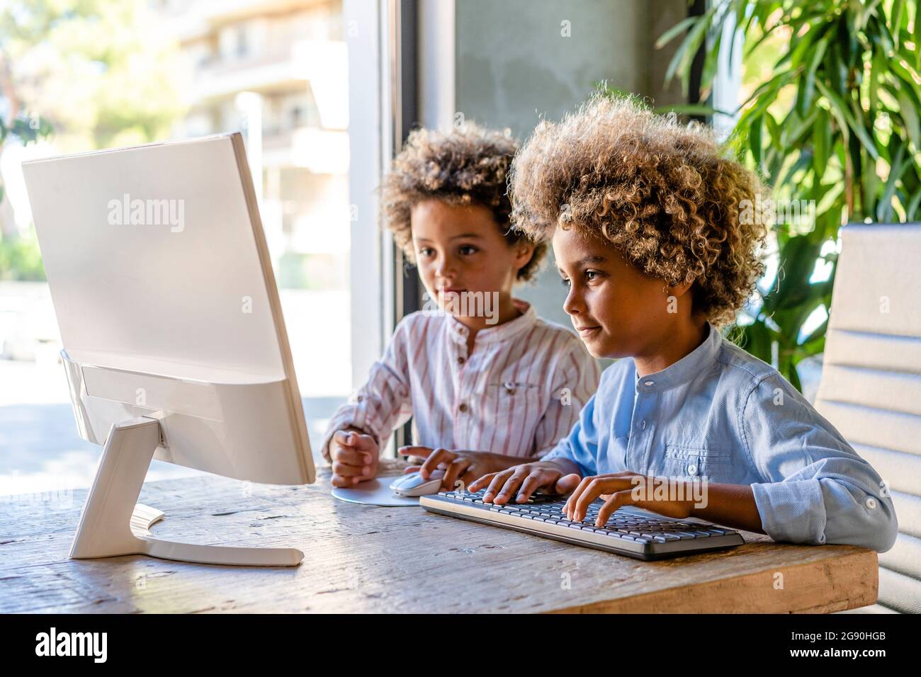 Boys computer sitting hi-res stock photography and images - Alamy