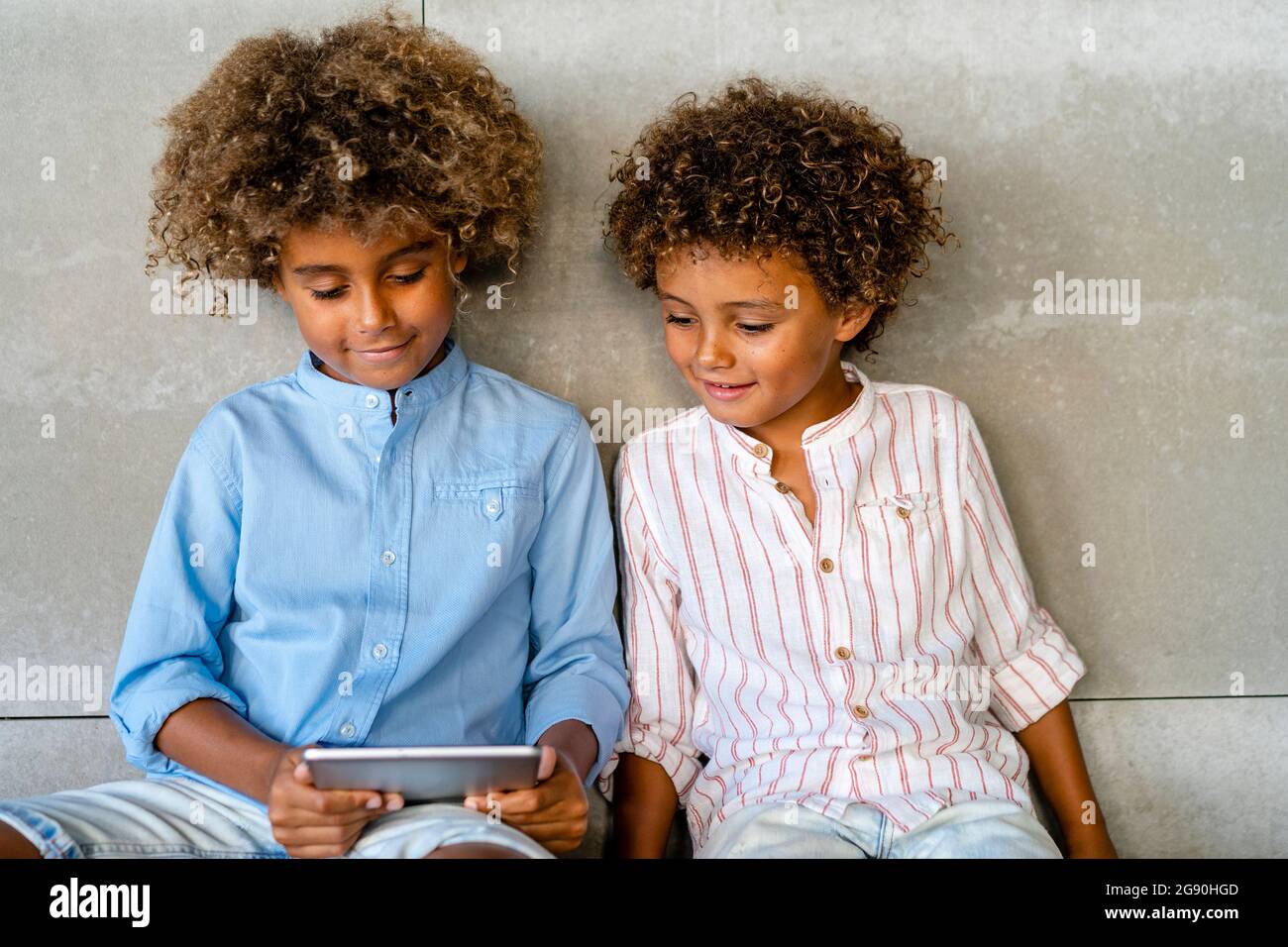 Boy sharing mobile phone with brother at home Stock Photo - Alamy