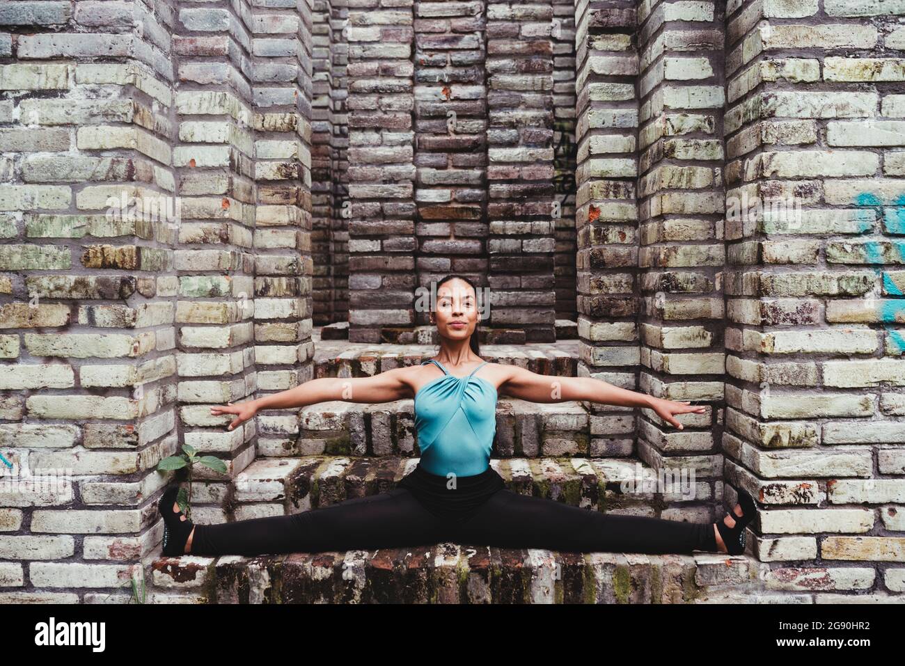 Smiling young woman doing the splits on steps Stock Photo - Alamy