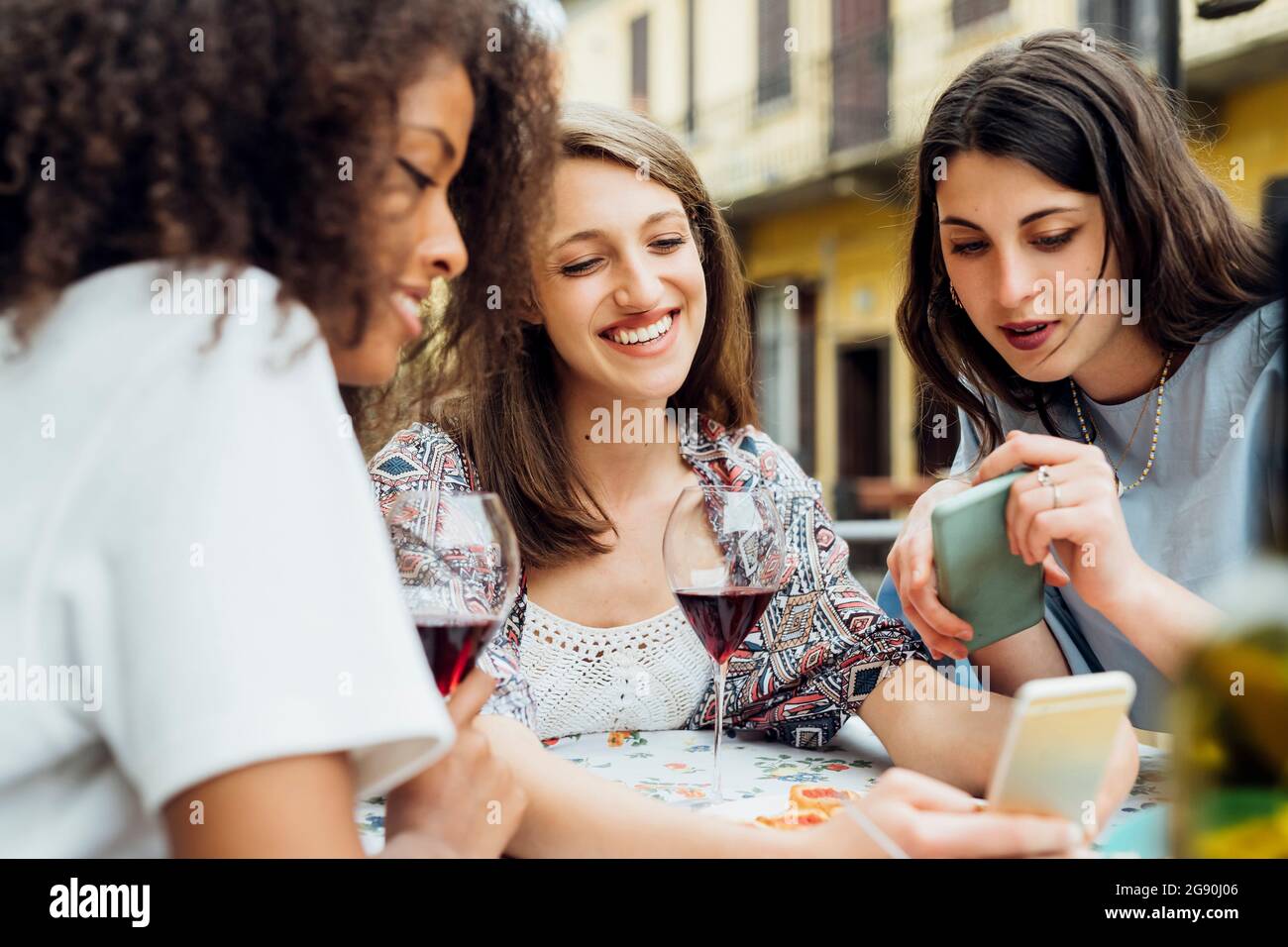 Friends using mobile phones at terrace Stock Photo - Alamy