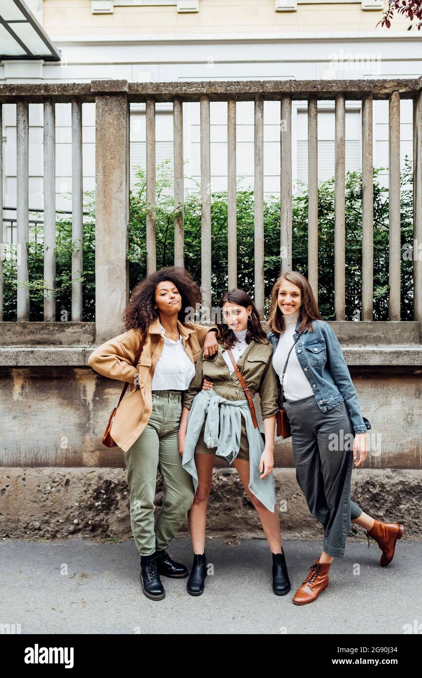 Smiling friends standing together on road Stock Photo - Alamy